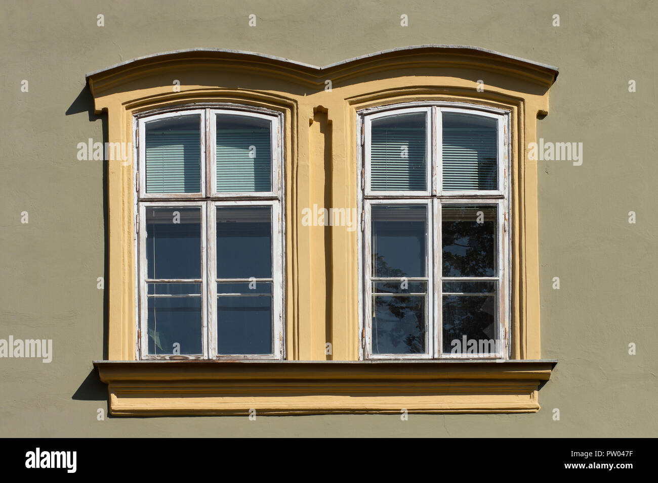 Vintage looking double window in European style, green facade with ...