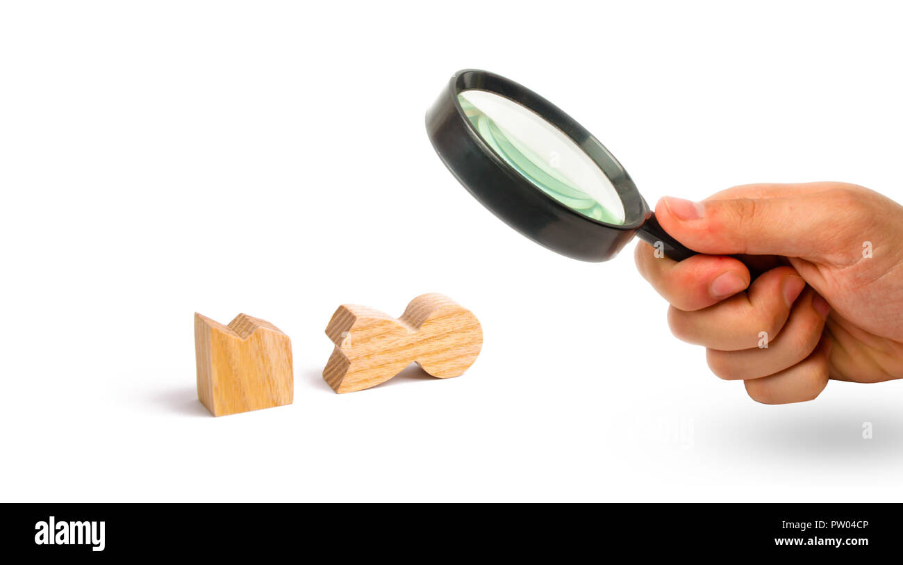 Magnifying glass is looking at a wooden figure of a man is broken. The ...