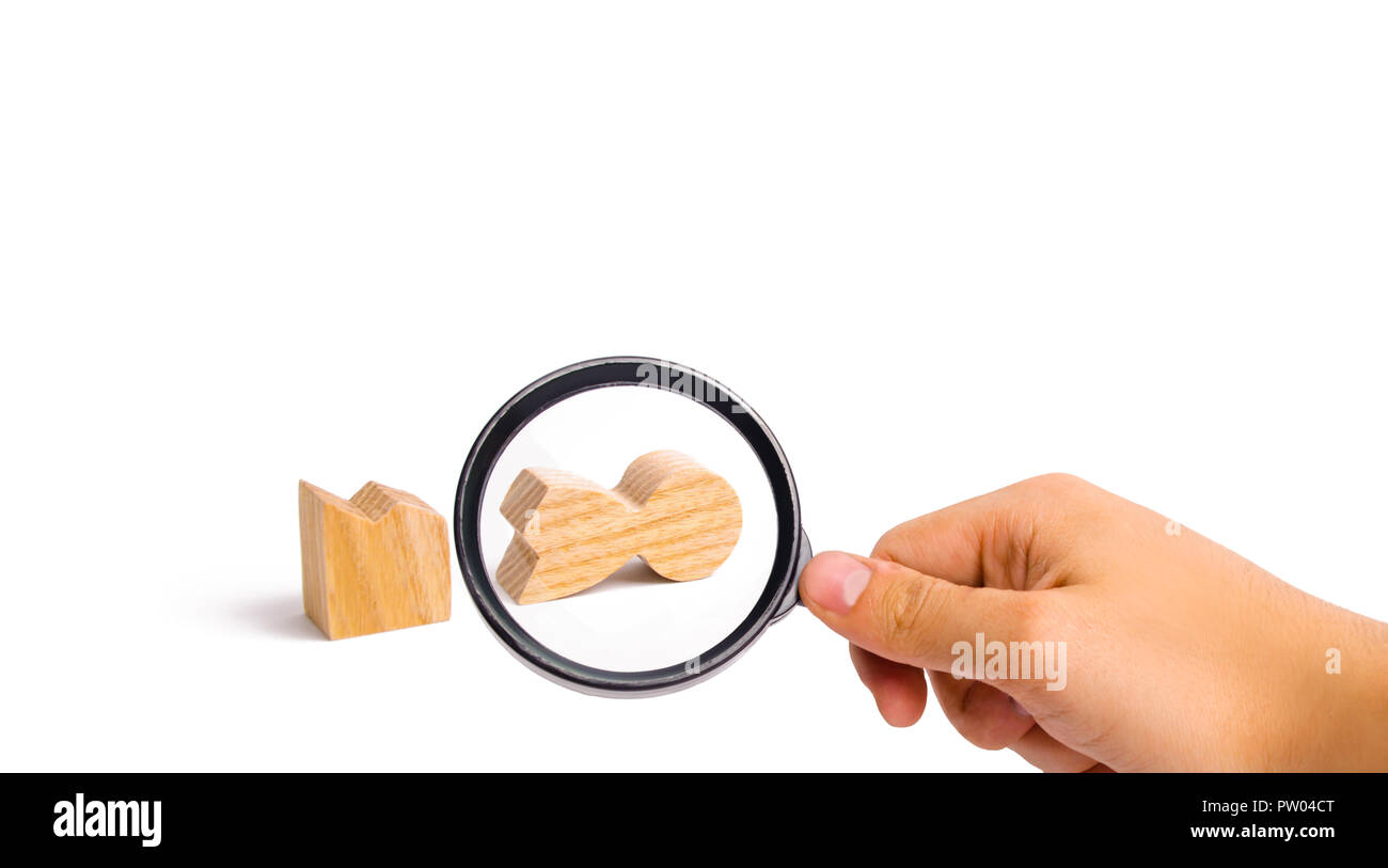 Magnifying glass is looking at a wooden figure of a man is broken. The ...