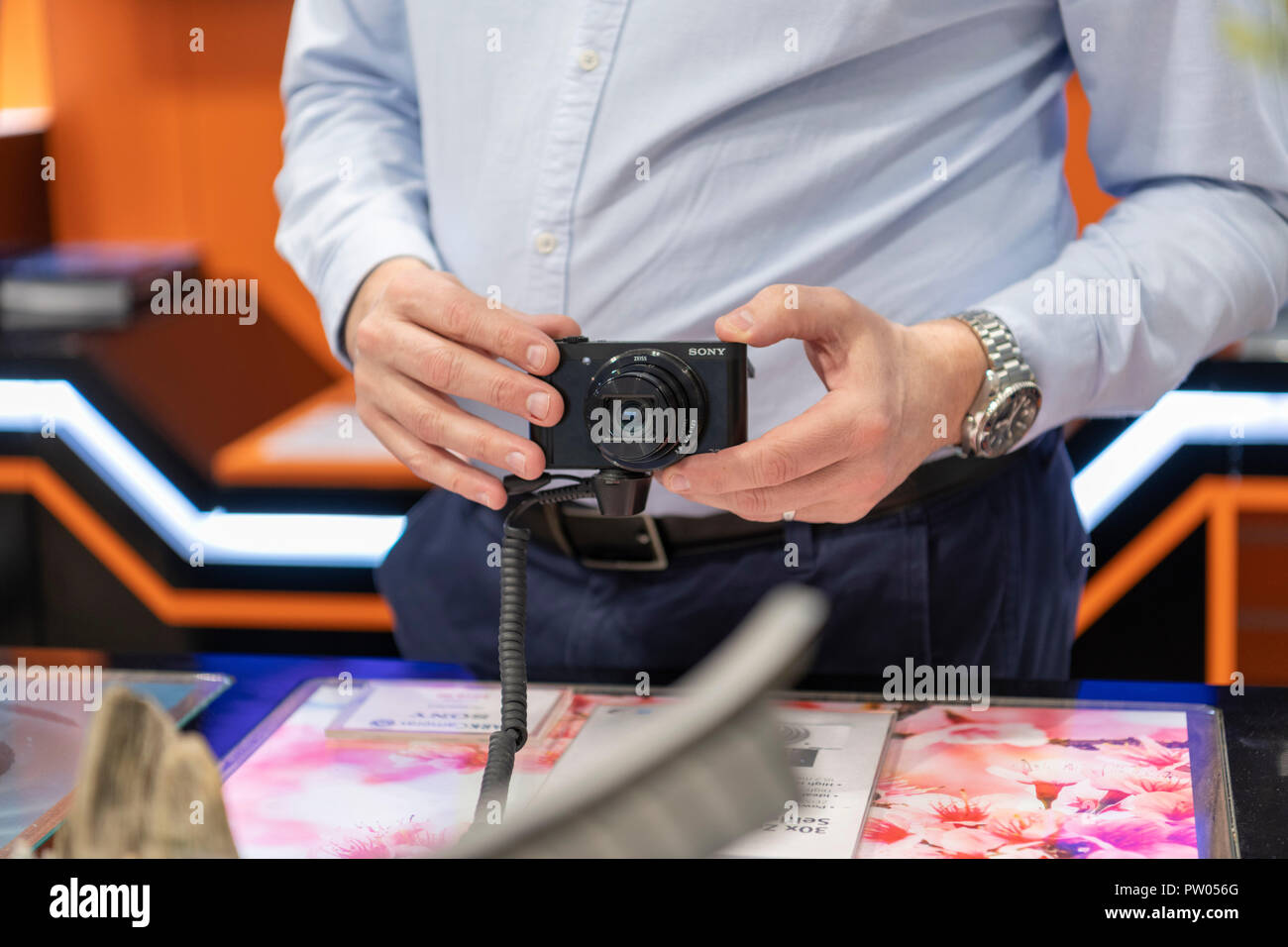 Man handling and trying a Sony RX100 Compact Camera in camera shop ...