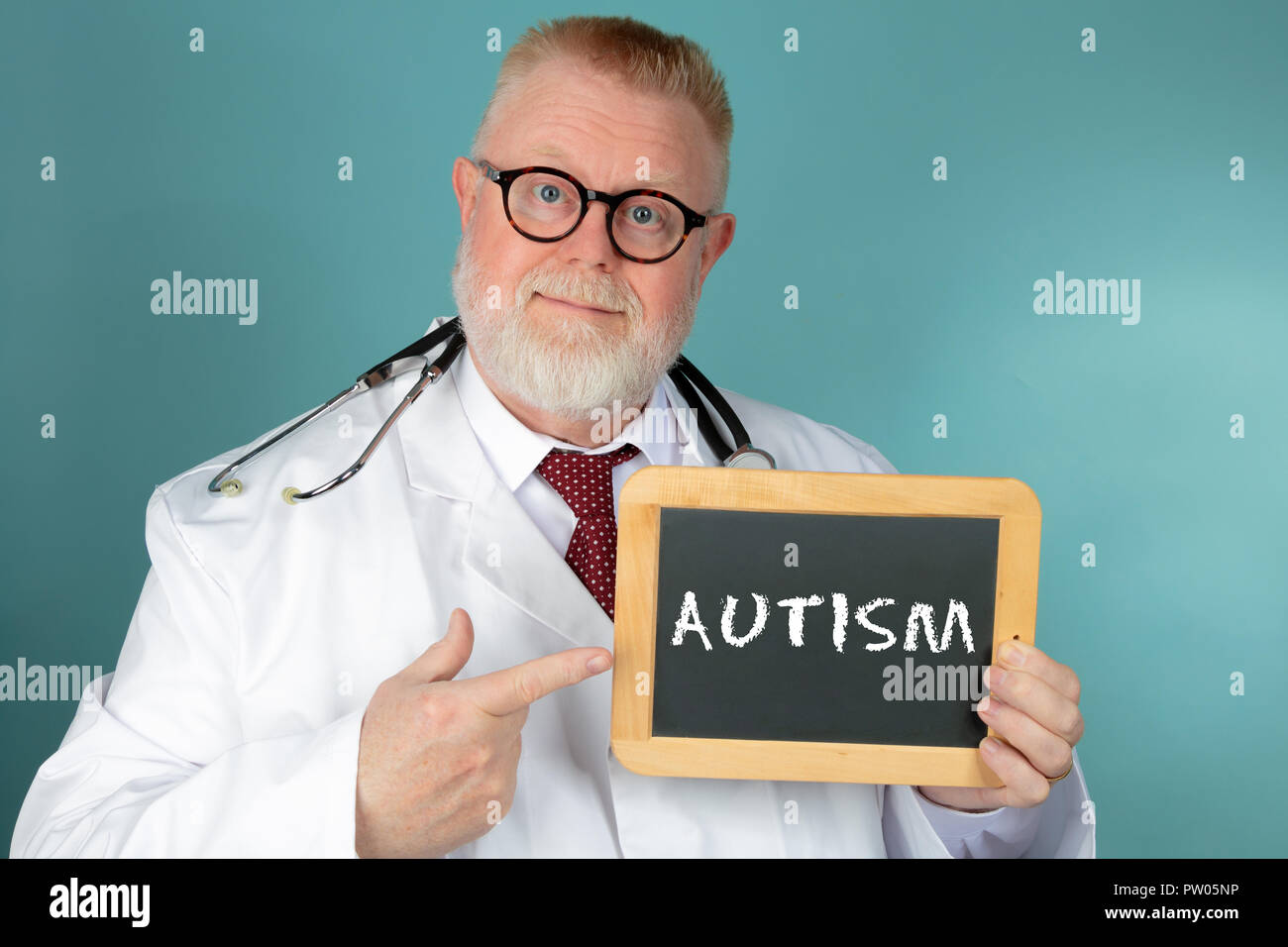Doctor with eyeglasses holding chalkboard with lettering Autism on blue ...