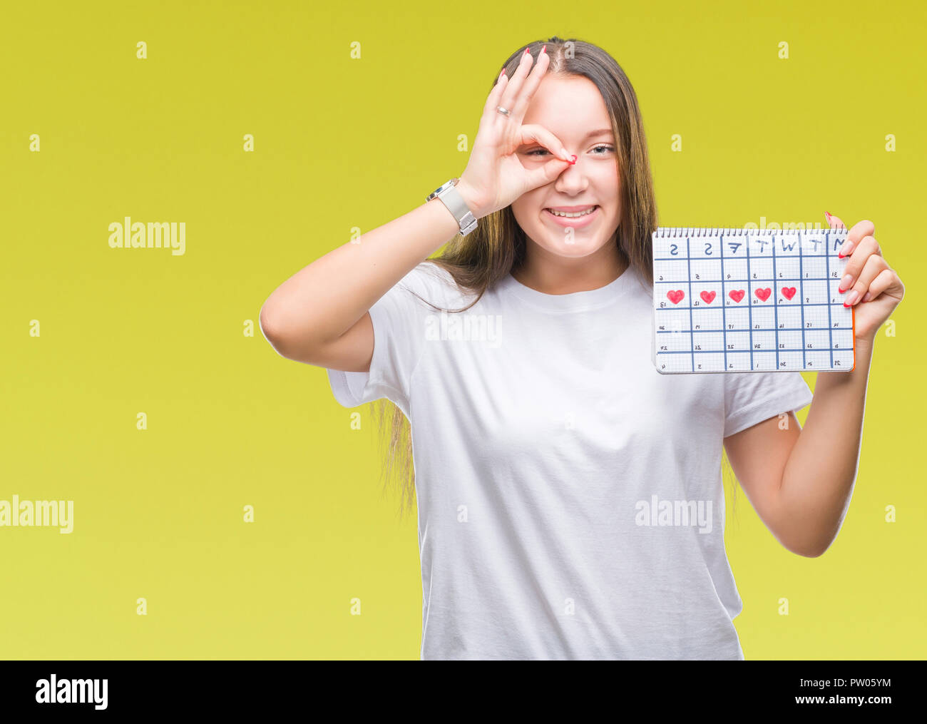 Young caucasian woman holding menstruation calendar over isolated ...