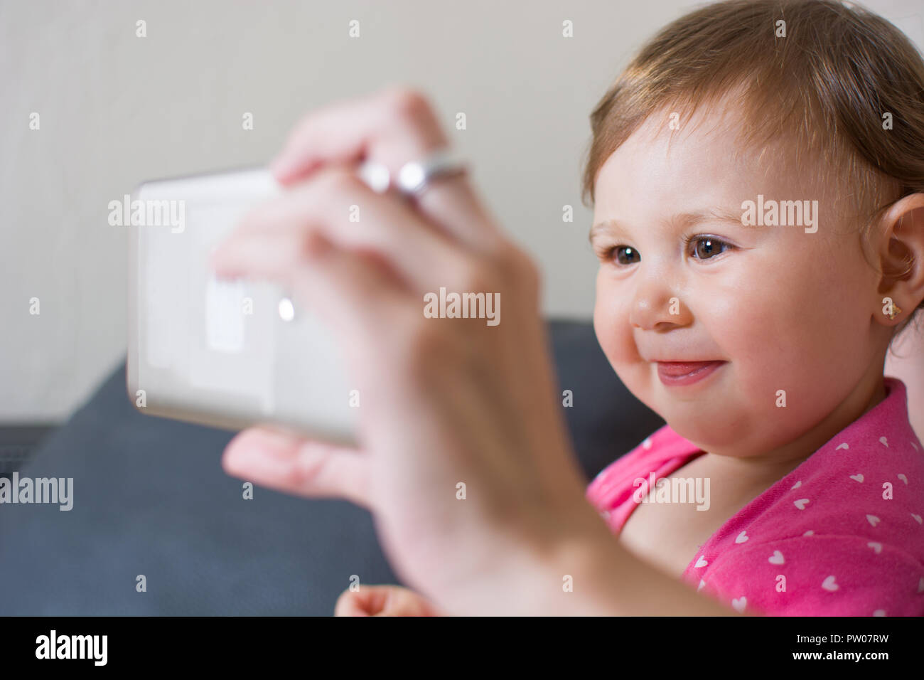 Mother and little baby girl with mobile phone at home Stock Photo - Alamy