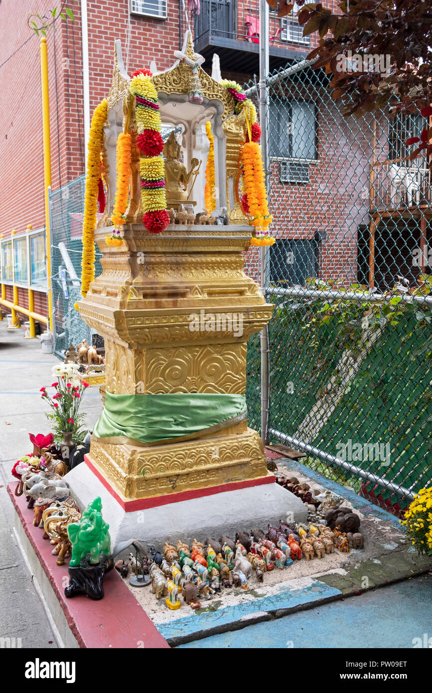 A statue of the Buddah, surrounded by dozens of small model elephants ...