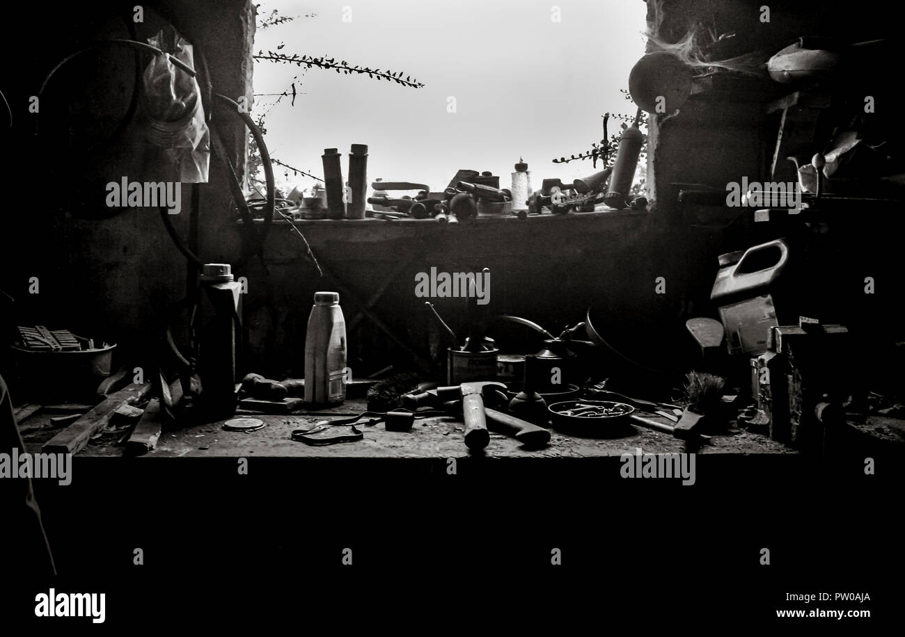 Old workbench, with old tools, in disarray, lit by window,various ...