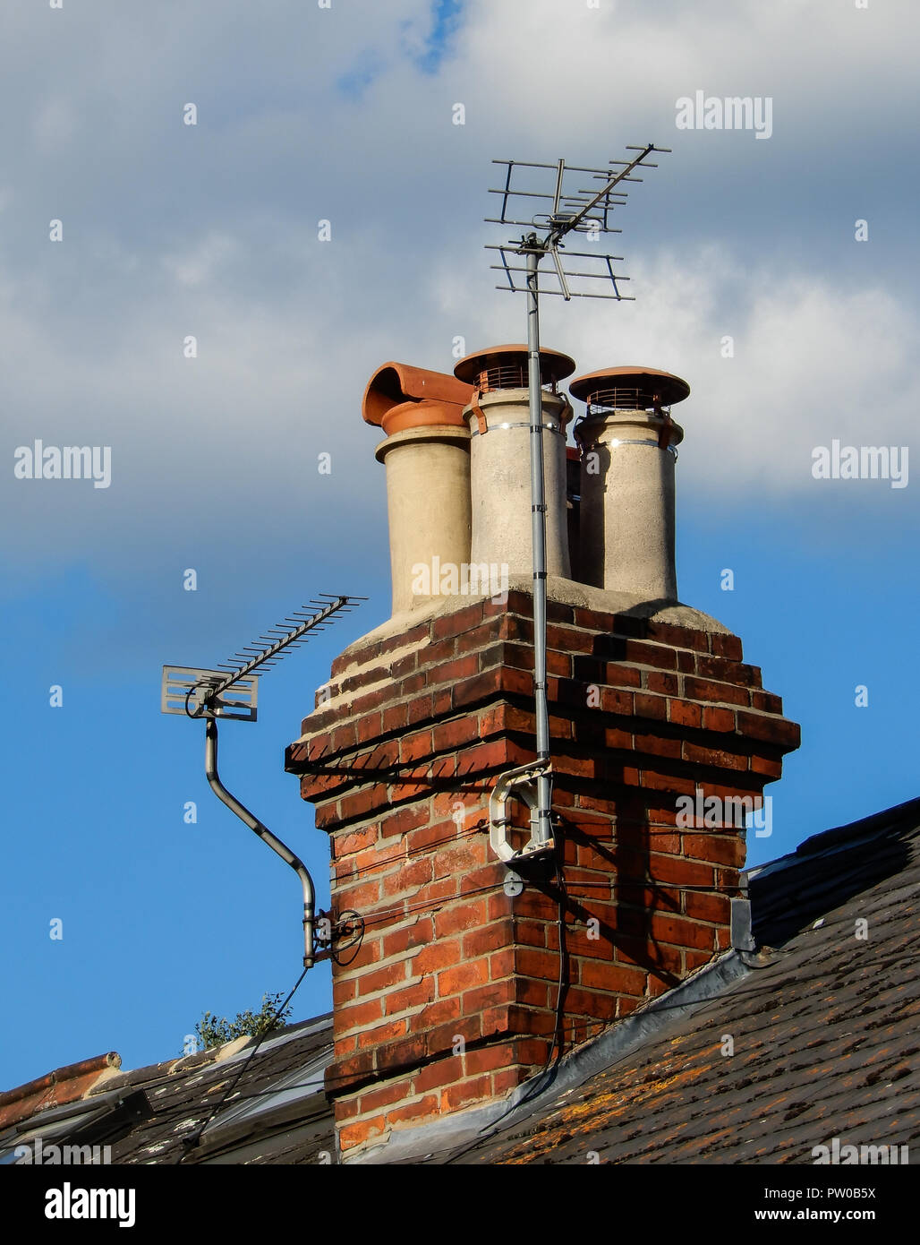 A Pair of Television aerials attached to a stack of four chimneys Stock ...