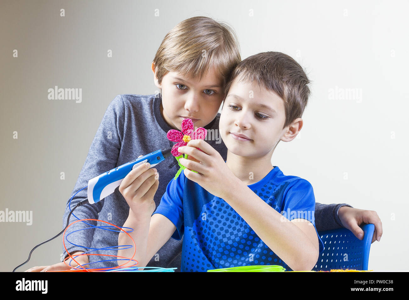Two boys creating with 3d printing pen Stock Photo - Alamy