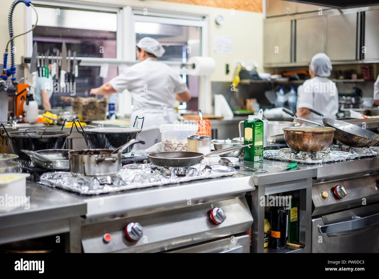 Kitchen staff busy with preparing food during lunch time in the ...