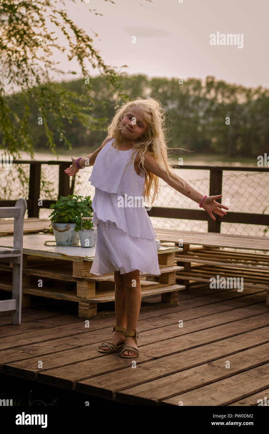 adorable little girl in dress at the pond outdoors in the afternoon ...
