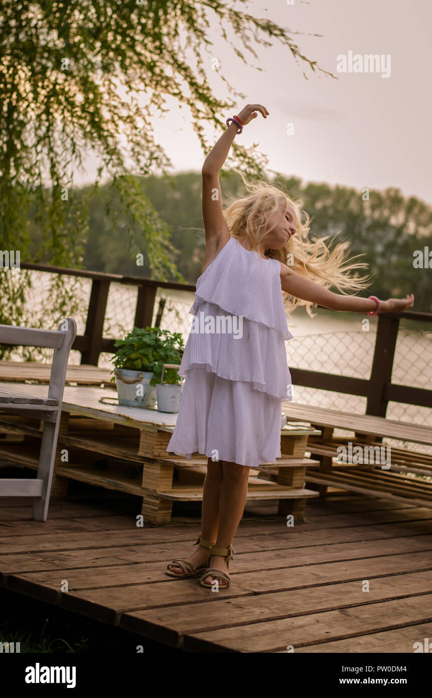 adorable little girl in dress at the pond outdoors in the afternoon ...
