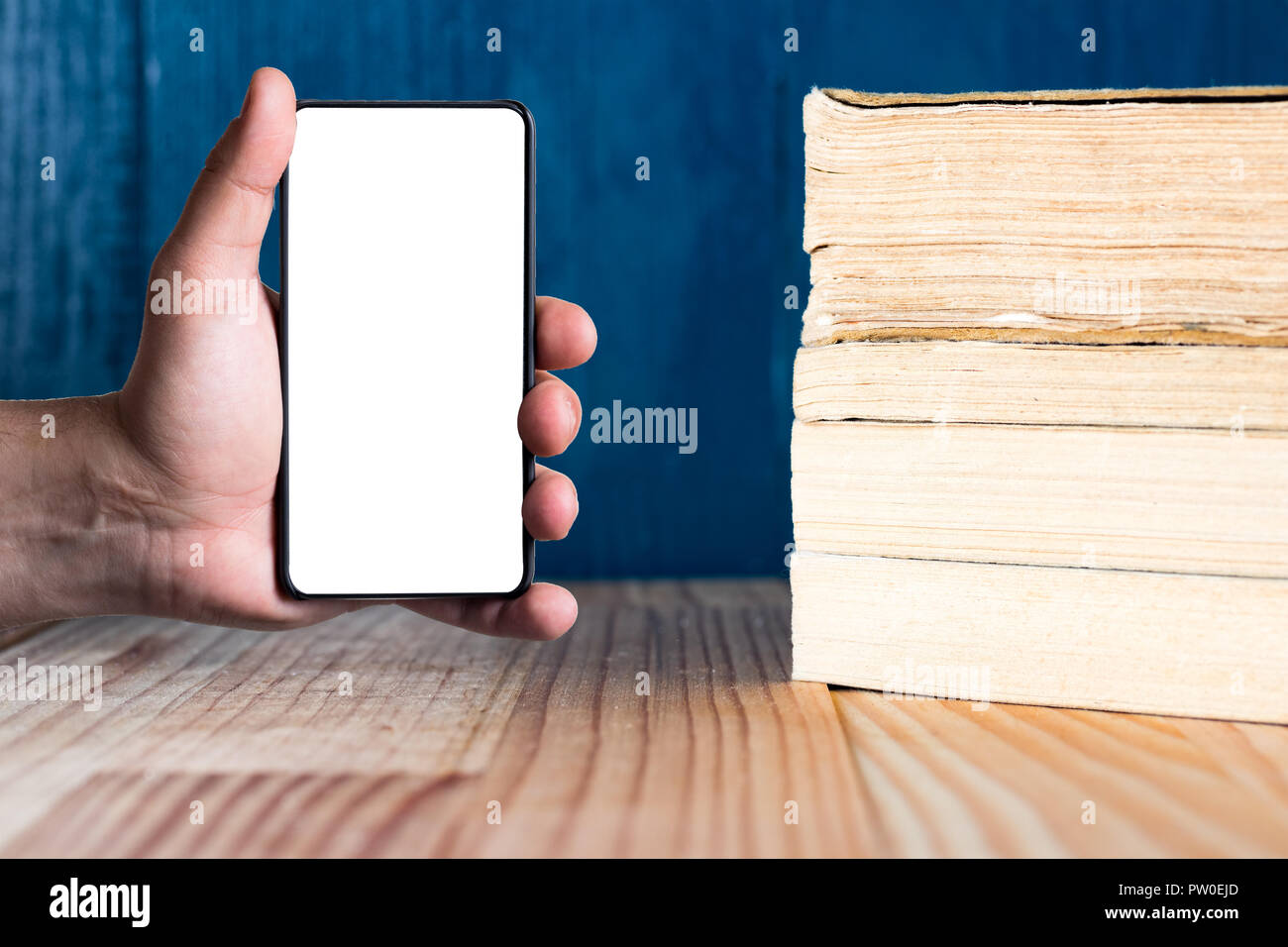 Modern bezel less smart phone with blank screen and pile of books on a ...