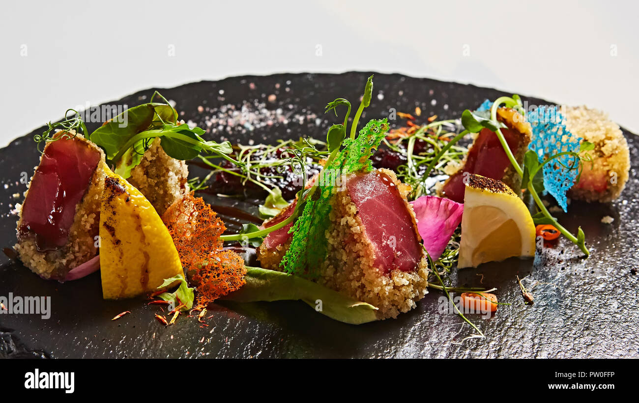 Close up of rare seared Ahi tuna slices with fresh vegetable salad on a ...