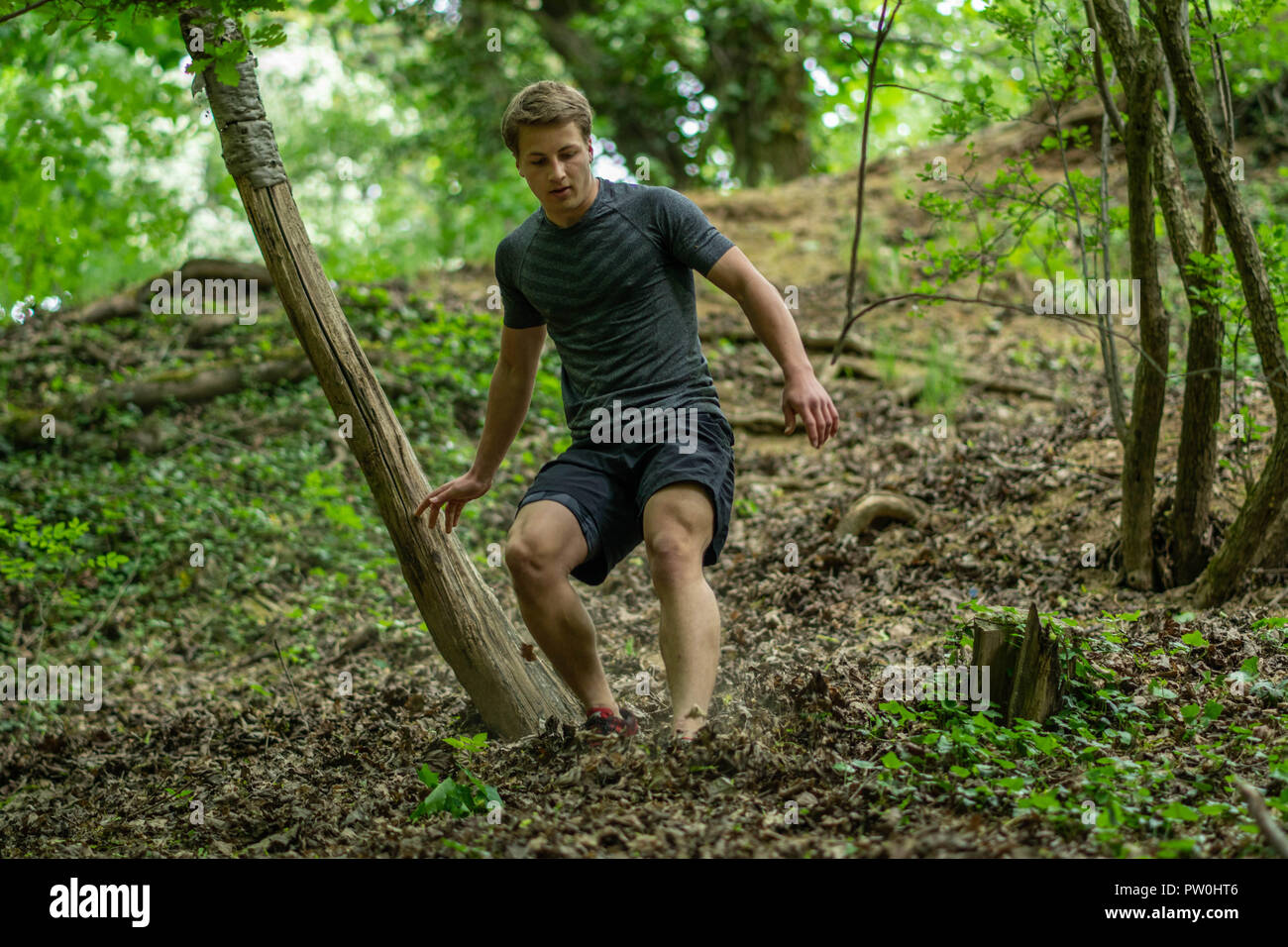 the guy is running down a steep hill while participating in an ocr race ...
