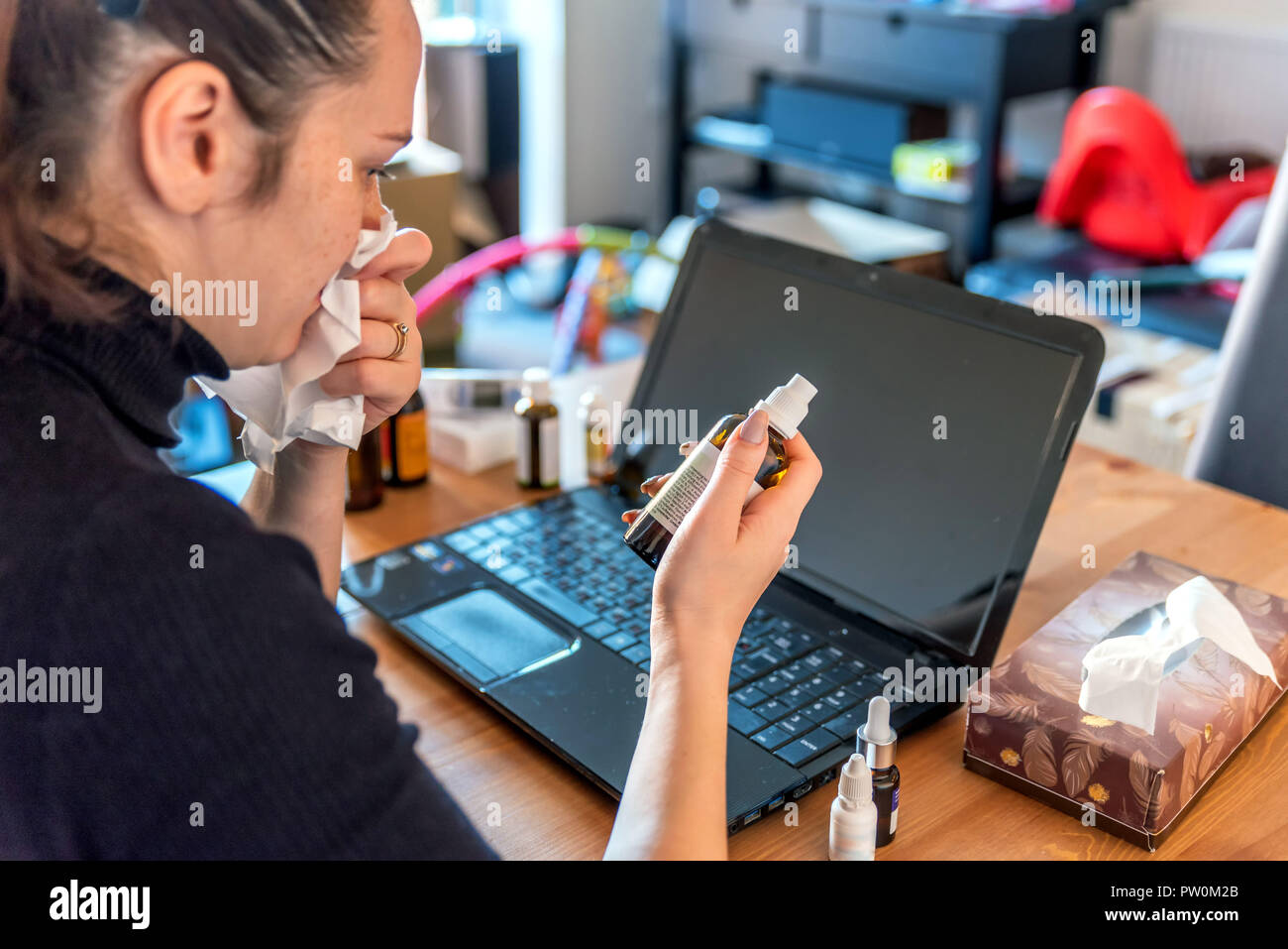 young sick woman working from home on laptop next to medicines Stock ...