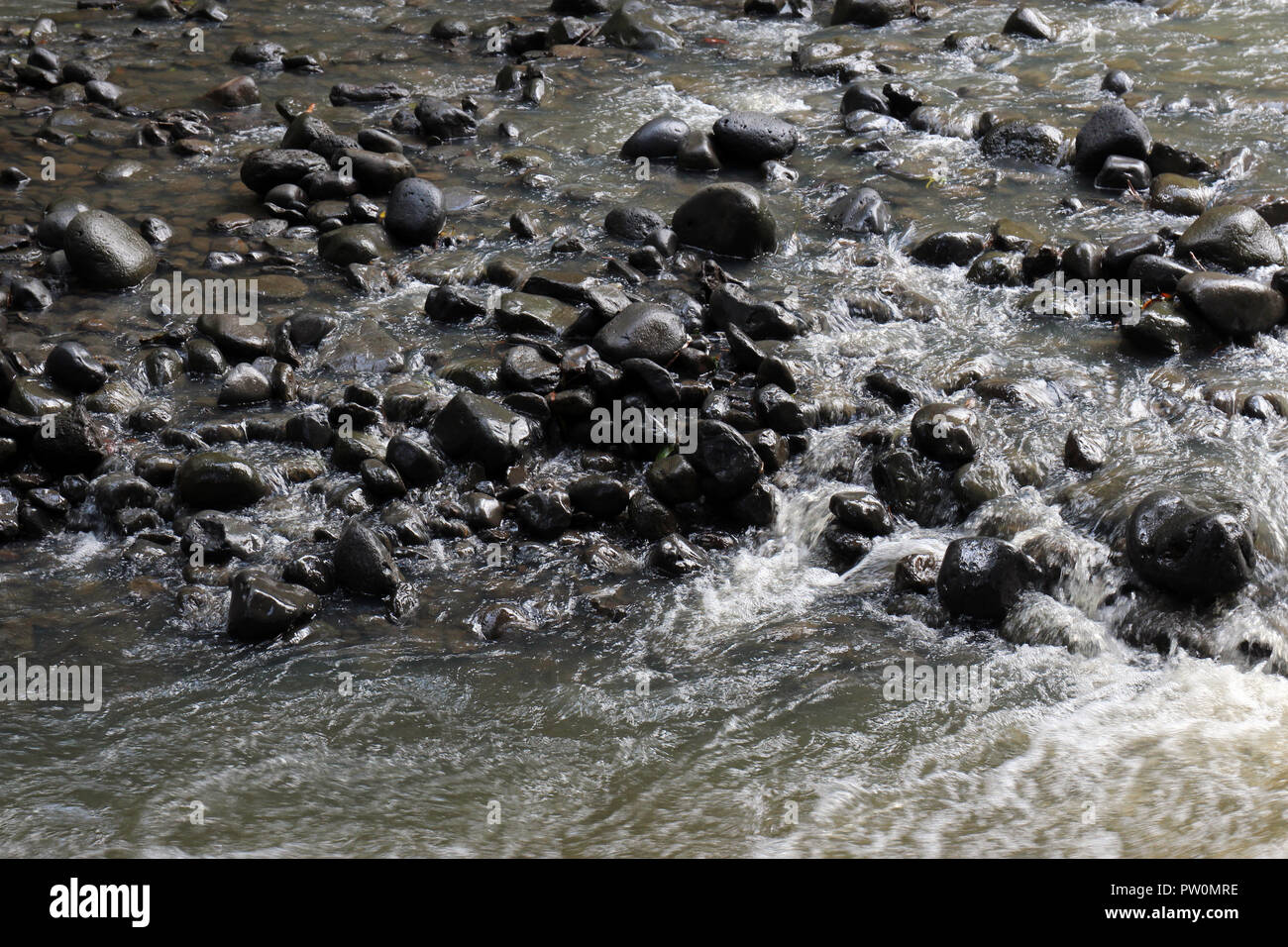Close up of gently rushing water over slippery, wet pebbles at Ho'olawa ...