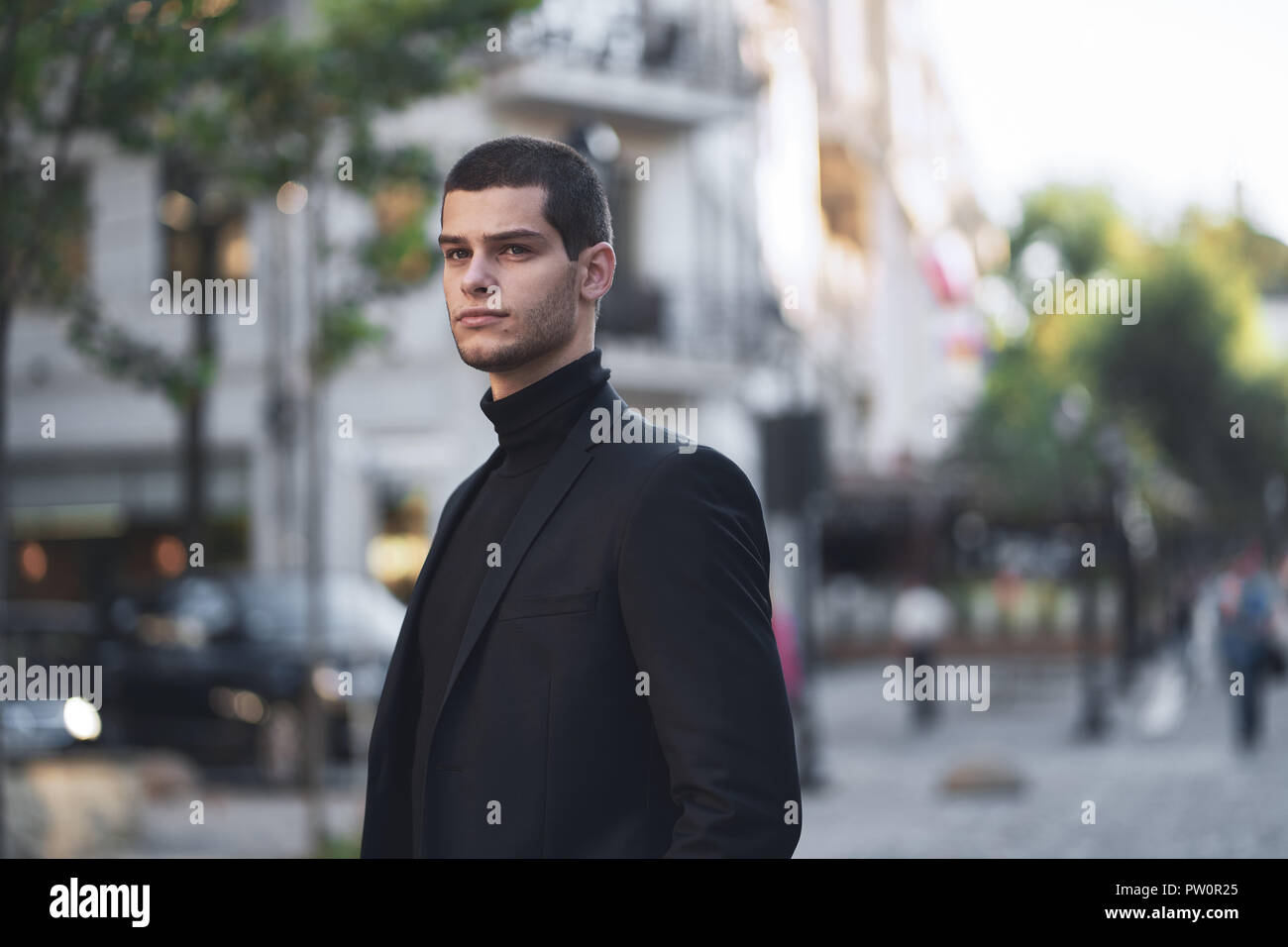 Young man walking, smart casual on an autumn day on a street of ...