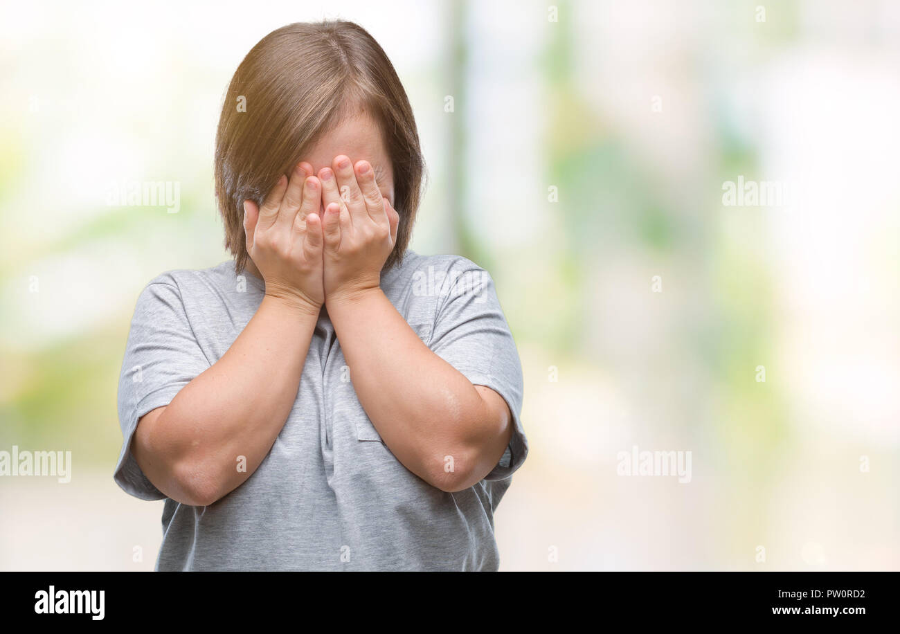 Young adult woman with down syndrome over isolated background with sad ...