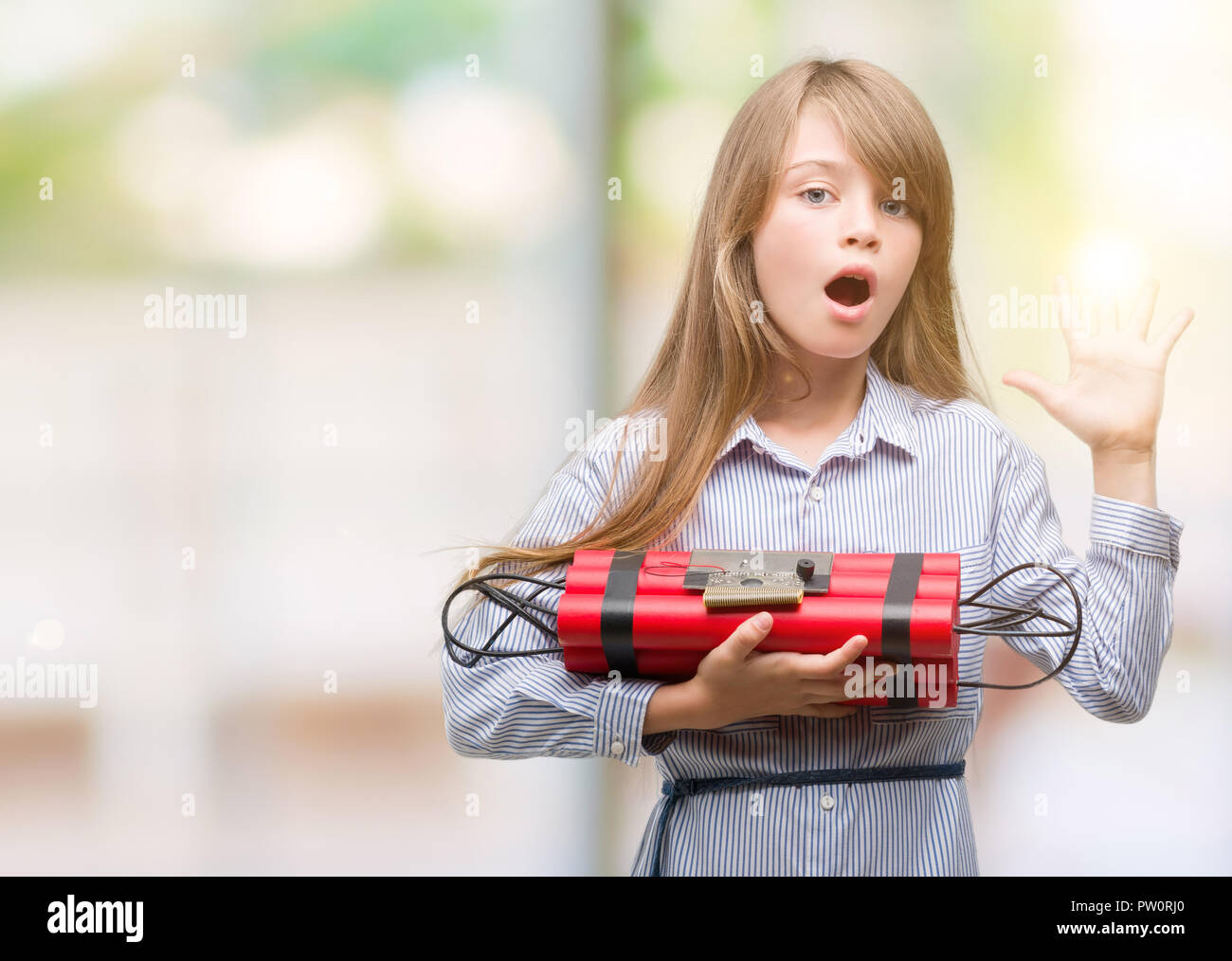 Young blonde child holding dynamite bomb very happy and excited, winner ...