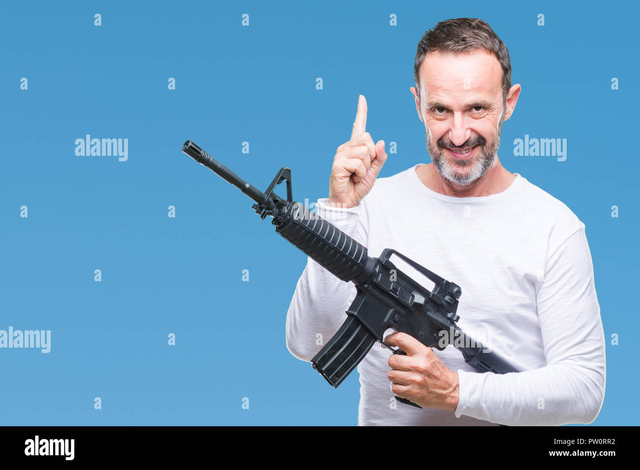 Middle age senior hoary criminal man holding gun weapon over isolated ...