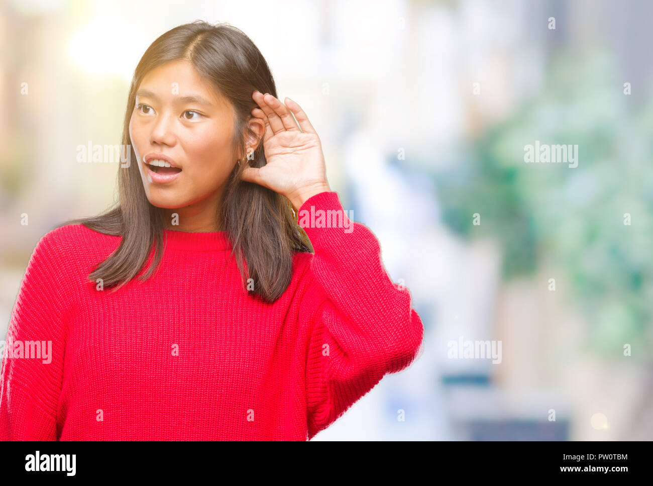 Young asian woman wearing winter sweater over isolated background ...