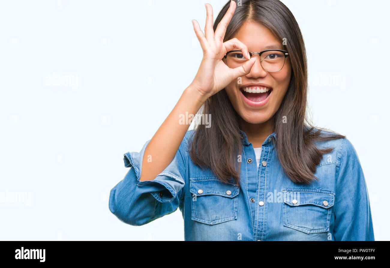 Young asian woman wearing glasses over isolated background doing ok ...