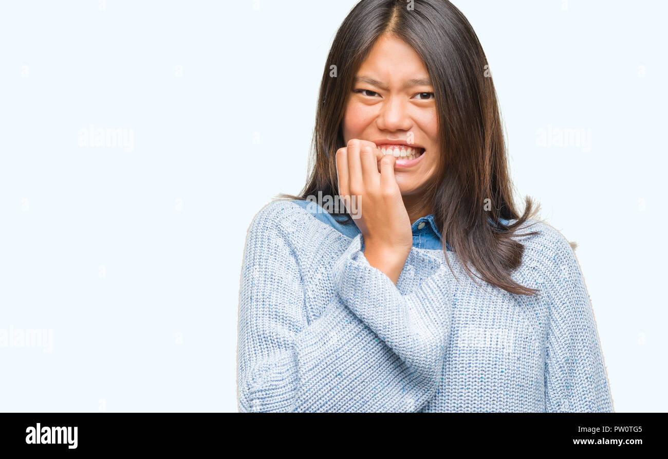 Young asian woman wearing winter sweater over isolated background ...