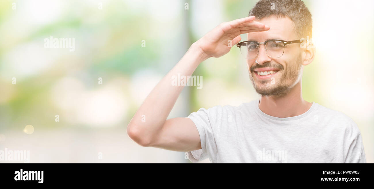 Young tattooed adult man very happy and smiling looking far away with ...