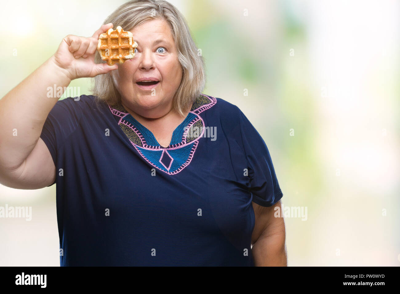 Senior plus size caucasian woman eating waffle over isolated background ...