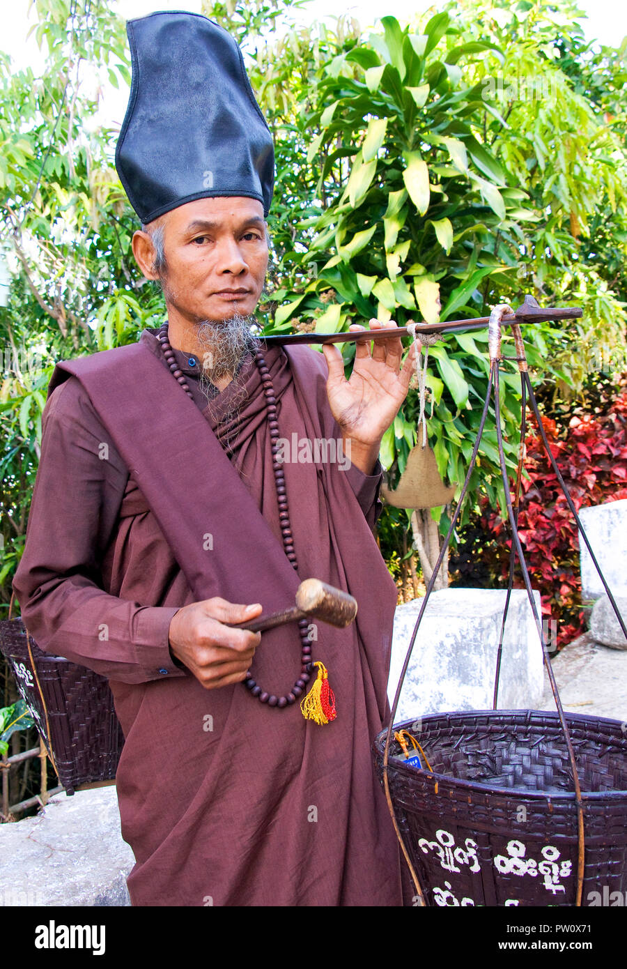 Buddhist monk with alms collection basket and bell at Golden Rock ...