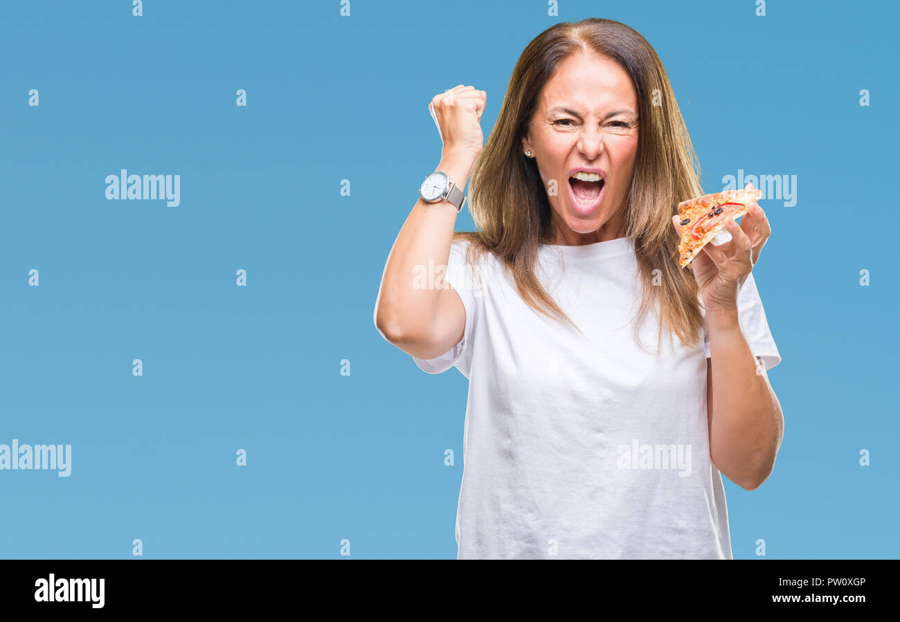 Middle age hispanic woman eating pizza slice over isolated background ...