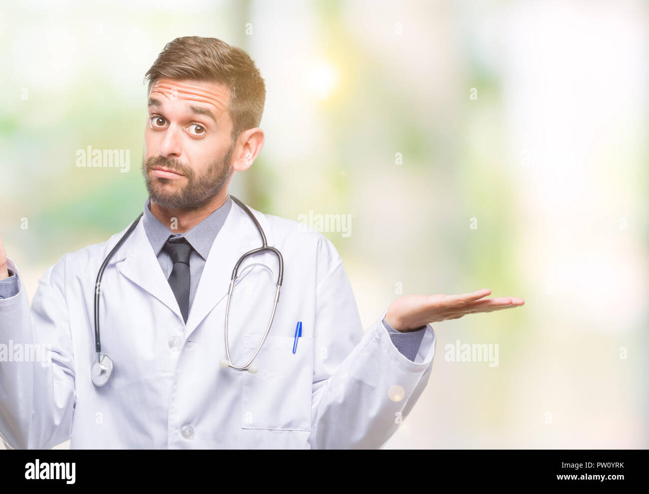 Young handsome doctor man over isolated background clueless and ...