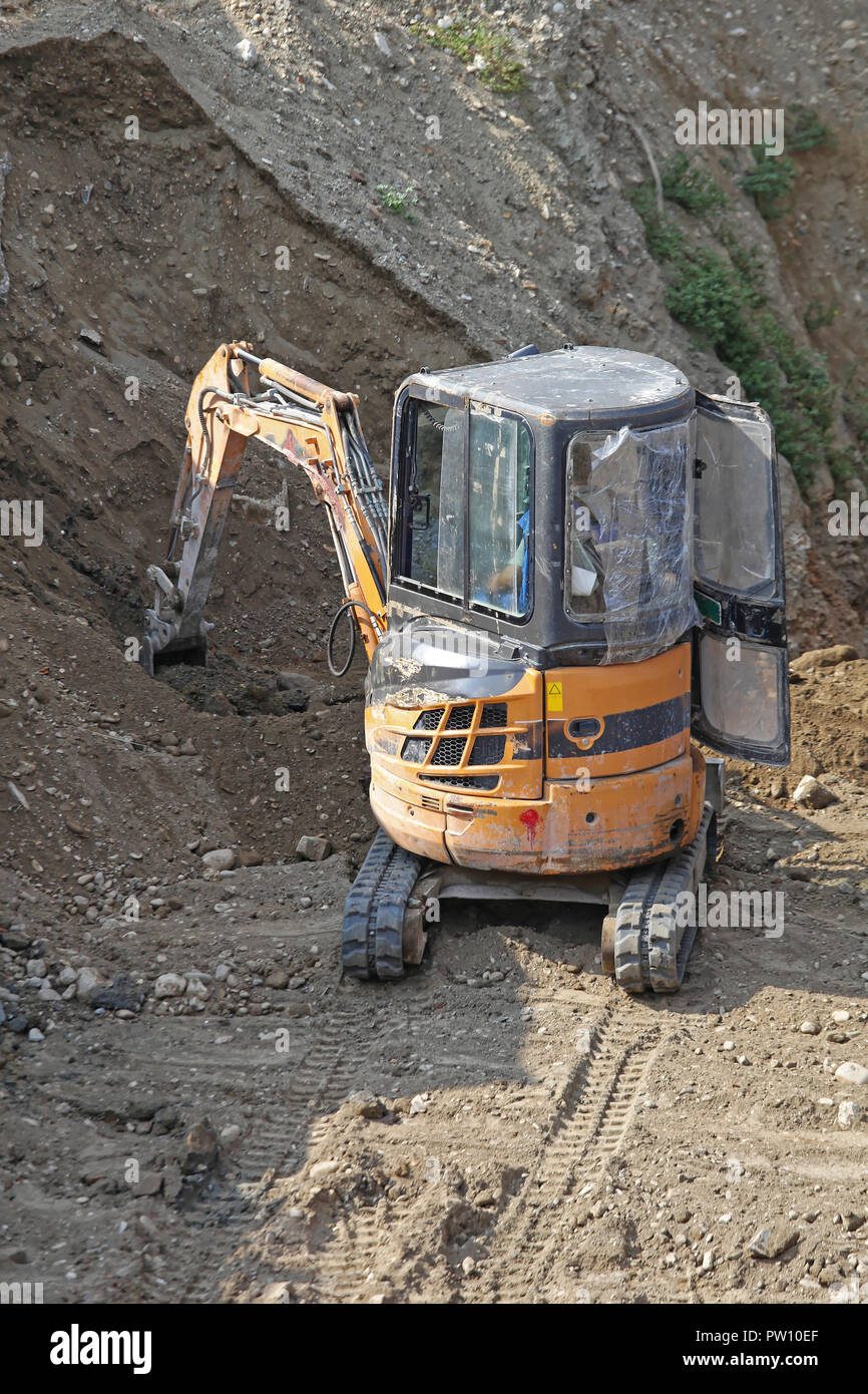 Mini Excavator Digging Earth at Construction Site Stock Photo - Alamy