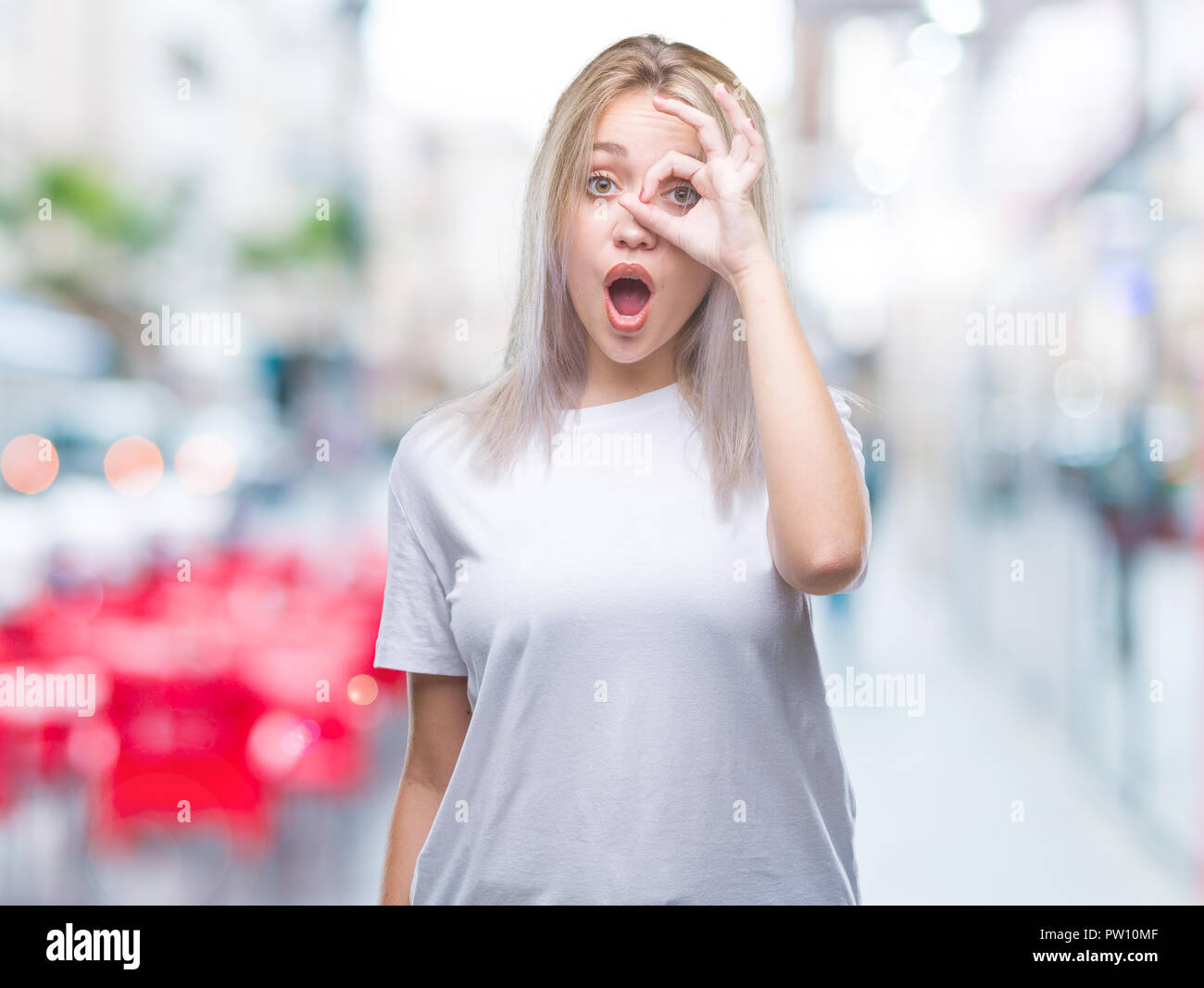 Young blonde woman over isolated background doing ok gesture shocked ...