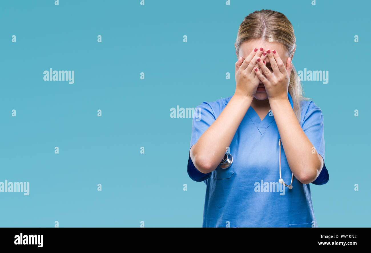 Young blonde surgeon doctor woman over isolated background with sad ...
