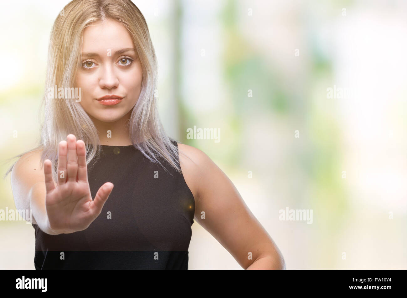 Young blonde woman over isolated background doing stop sing with palm ...