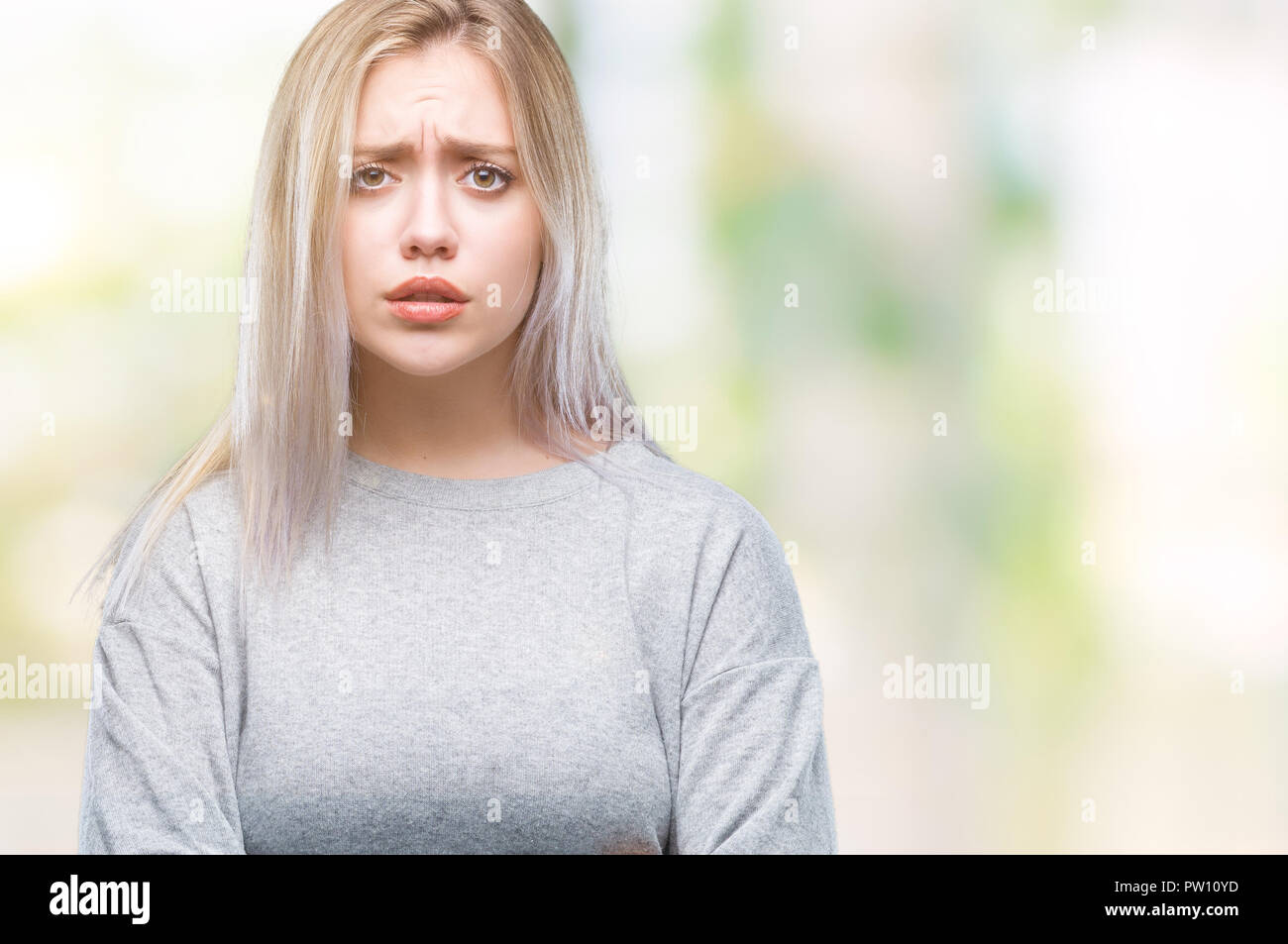 Young blonde woman over isolated background skeptic and nervous ...