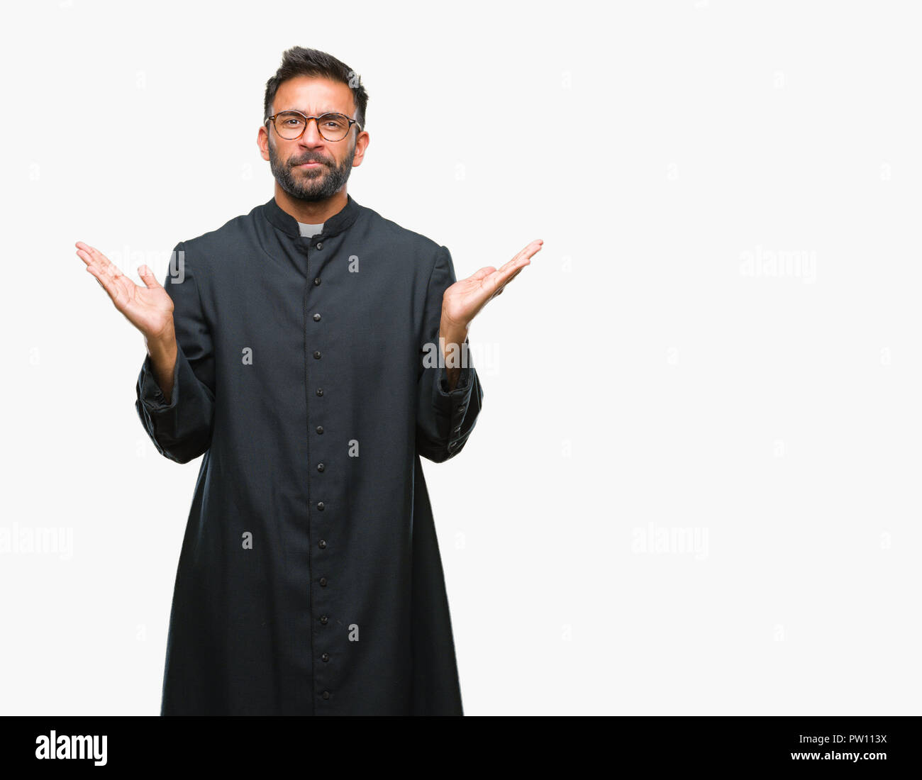 Adult hispanic catholic priest man over isolated background clueless ...