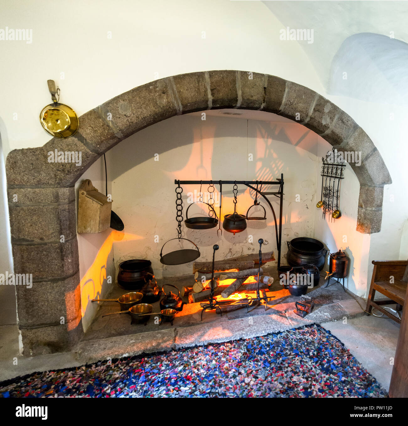 Cooking pots in a decorative lighted fireplace in one of the room of ...