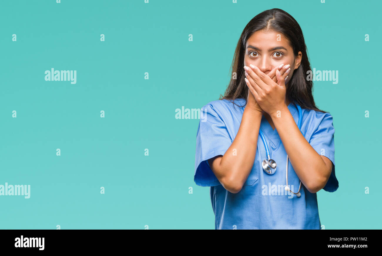 Young arab doctor surgeon woman over isolated background shocked ...