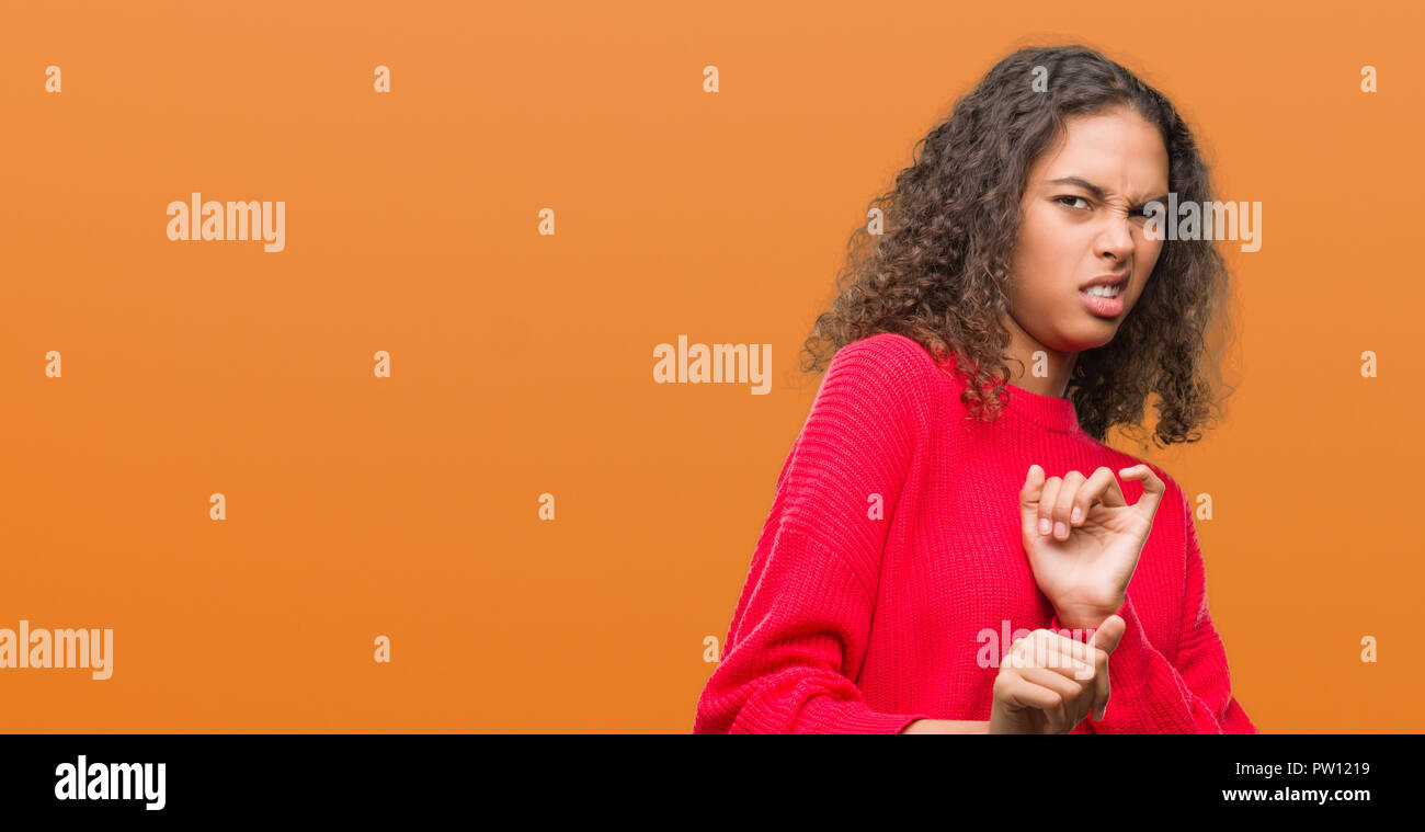 Young hispanic woman wearing red sweater disgusted expression ...