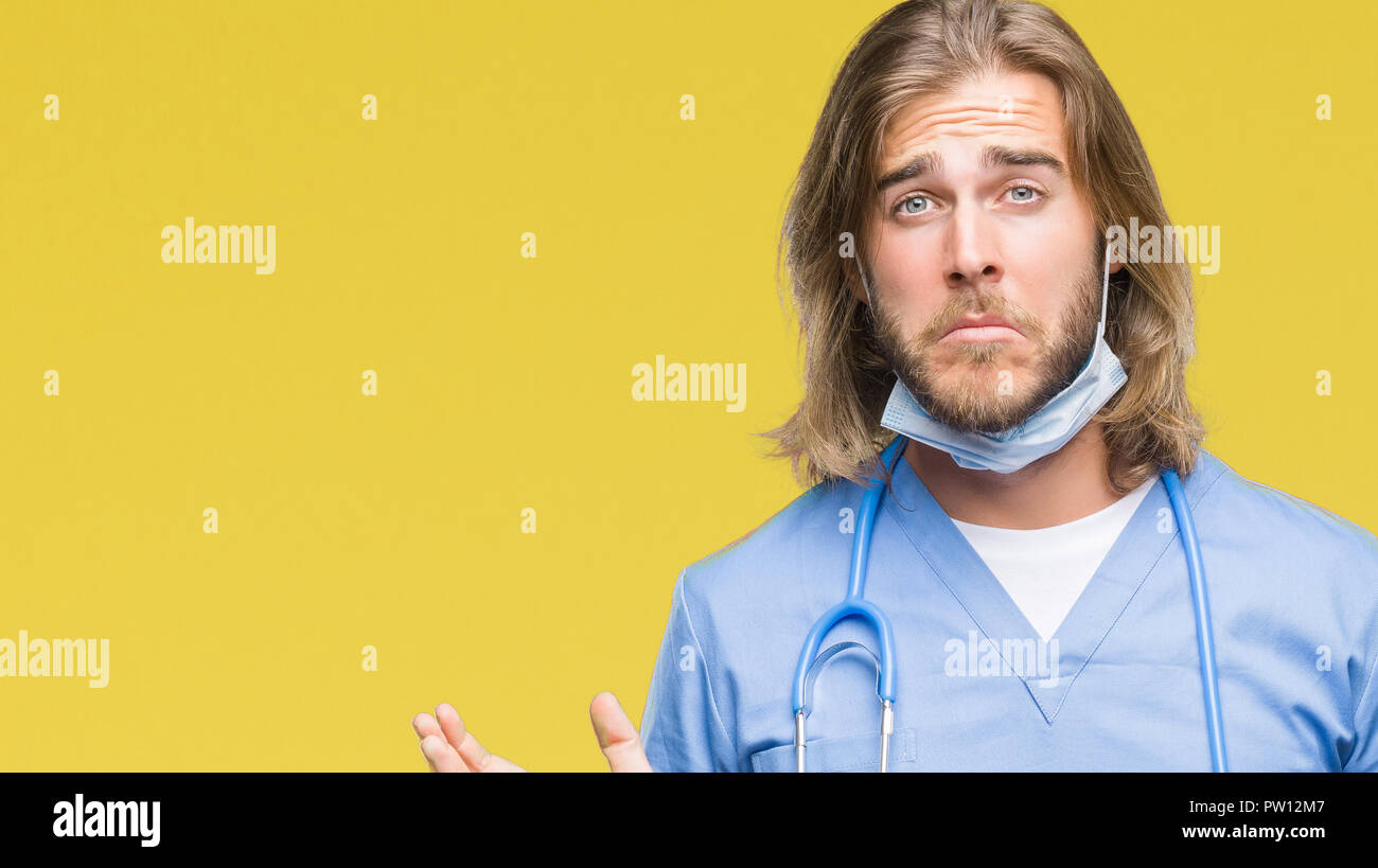 Young handsome doctor man with long hair over isolated background ...