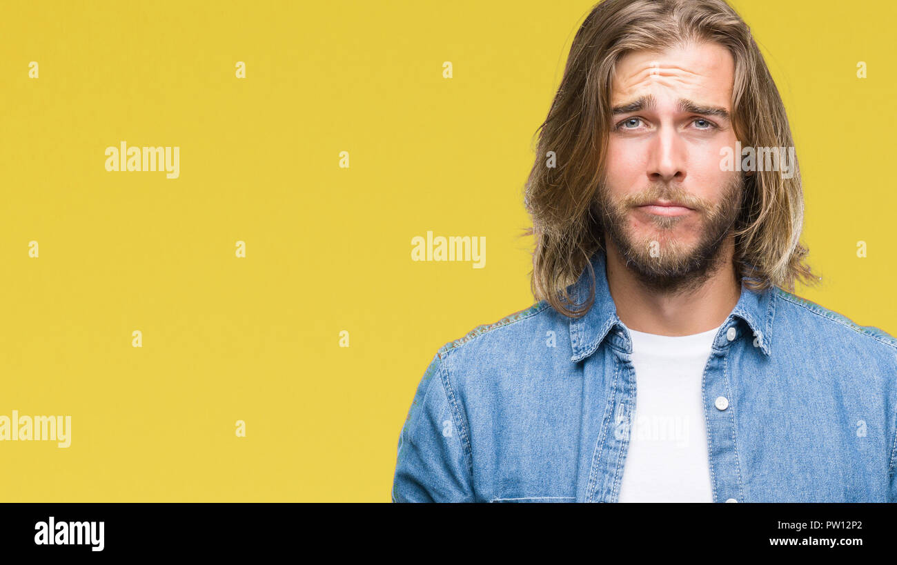 Young handsome man with long hair over isolated background depressed ...