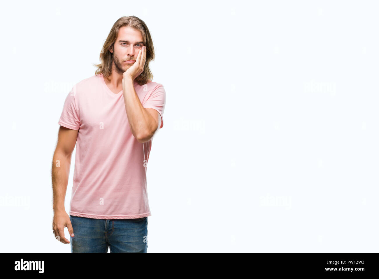 Young handsome man with long hair over isolated background thinking ...