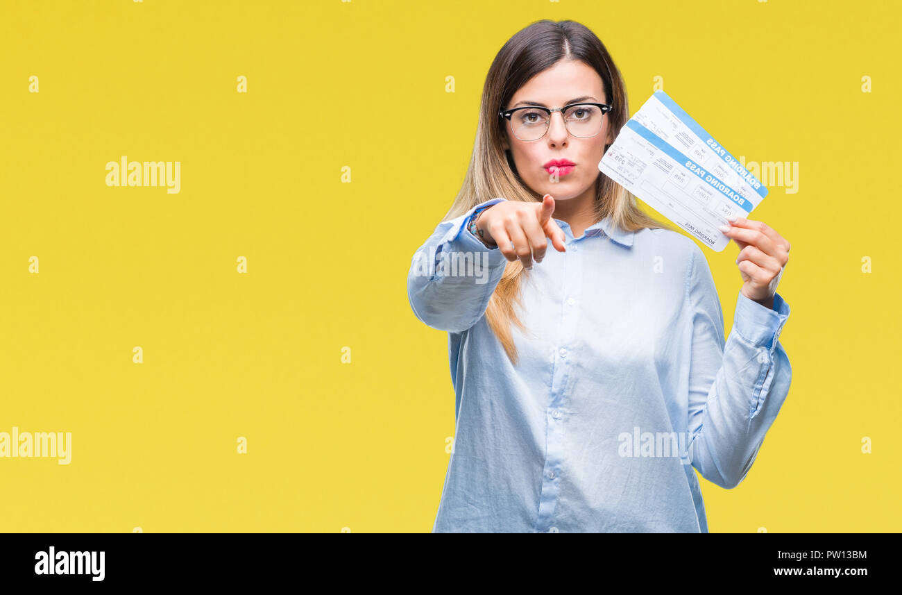 Young beautiful woman holding boarding pass over isolated background ...