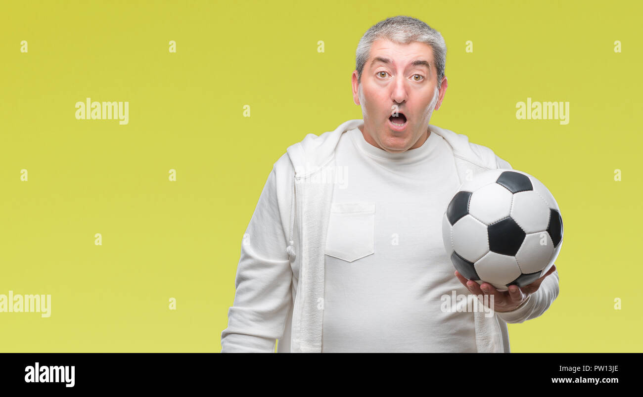 Handsome senior man holding soccer football ball over isolated ...
