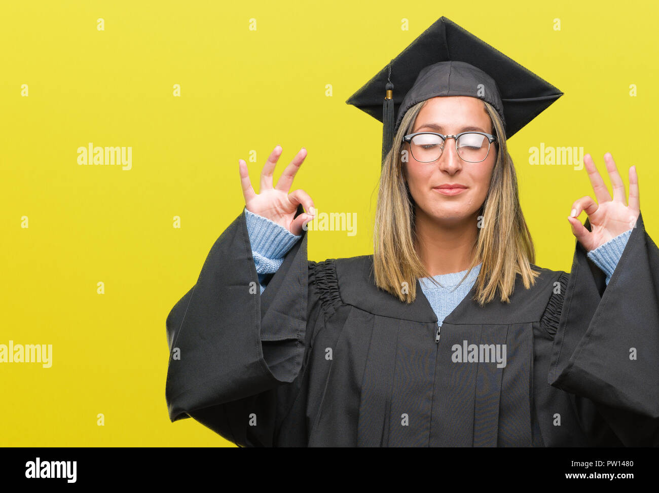 Young beautiful woman wearing graduated uniform over isolated ...
