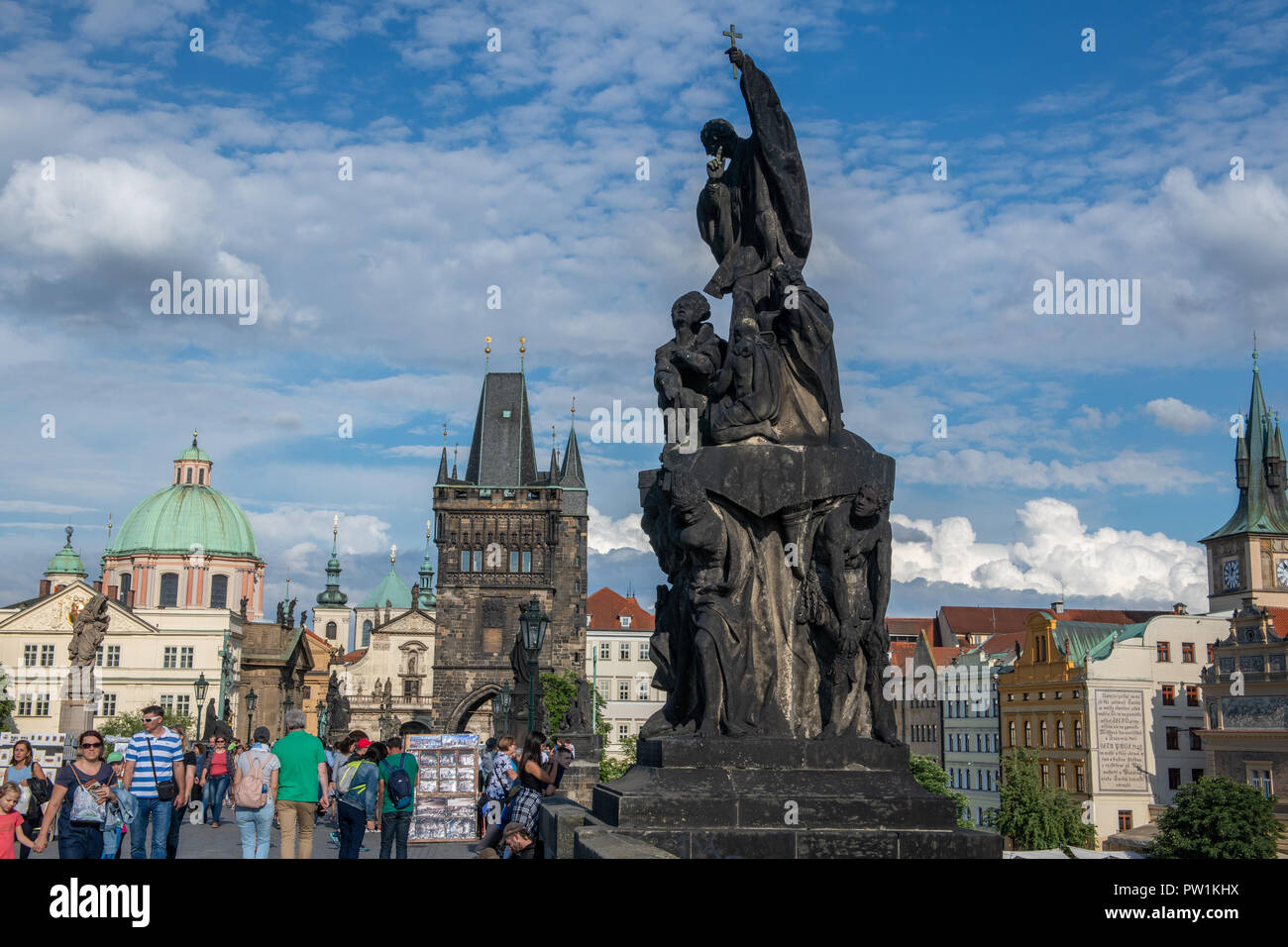 Pedestrians crossing Charles Bridge with gothic style sculpture in Prague - Czech Republic Stock ...