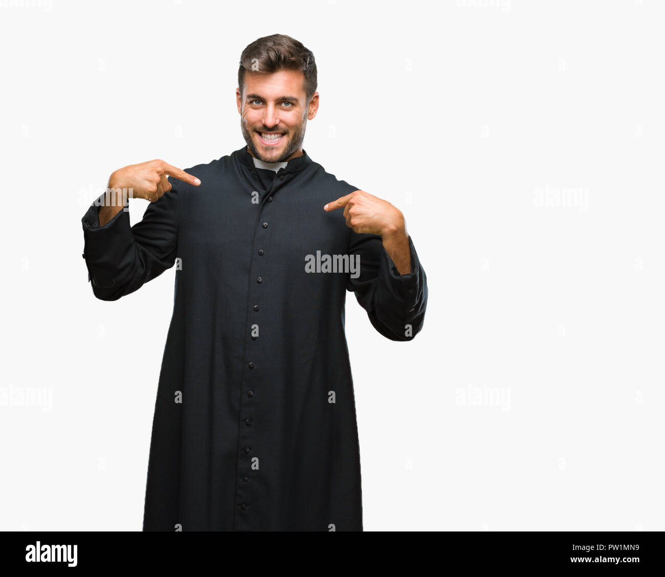 Young catholic christian priest man over isolated background looking ...