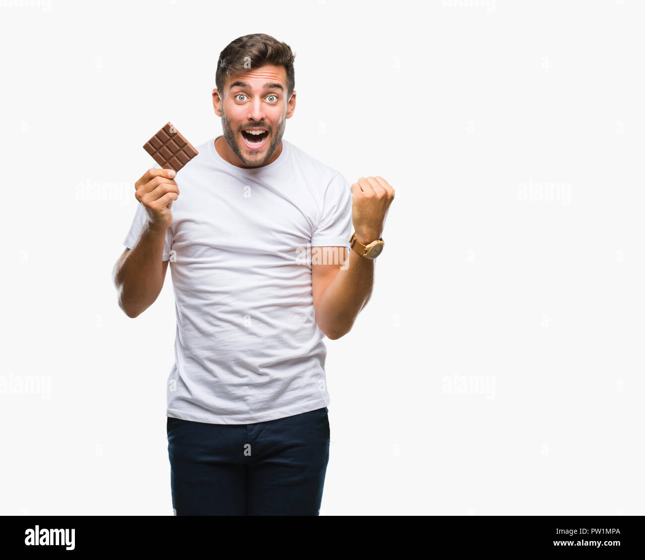 Young handsome man eating chocolate bar over isolated background ...