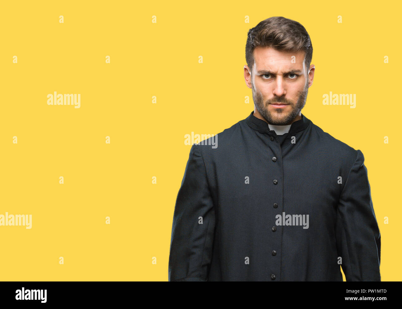 Young catholic christian priest man over isolated background skeptic ...